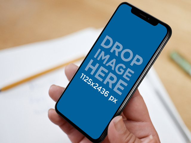 Placeit - Man Holding an iPhone 11 Pro Mockup on a Desk