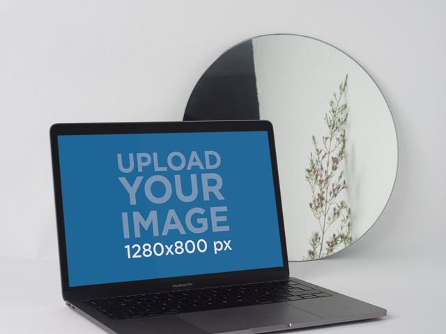 Placeit - MacBook Pro Mockup on a White Surface Near a Round Window