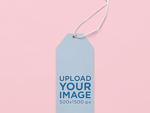 Placeit - Mockup of a Brand Tag With a Thread Lying on a Colored Surface