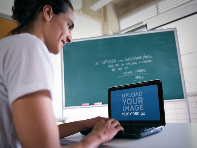 Placeit - Mockup Template of Male Student in Classroom Using an HP Laptop