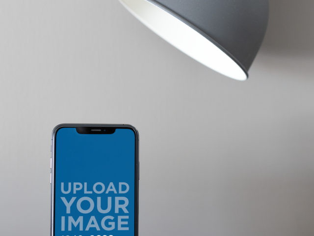Placeit - iPhone 11 Pro Max Mockup Standing Under a Desk Lamp