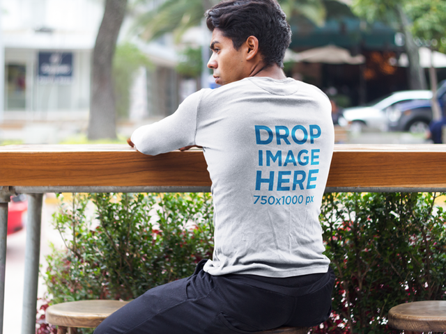 Placeit - Young Man Sitting on a Stool Long Sleeve Tee Mockup
