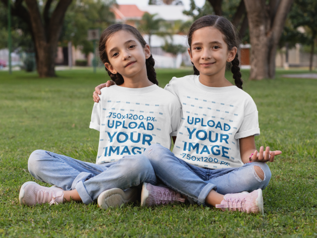 Placeit - T-Shirt Mockup of Twin Girls Sitting on the Grass