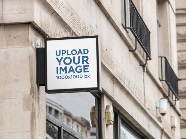 Placeit - Mockup of a Square Outdoor Sign on a Concrete Building's Corner