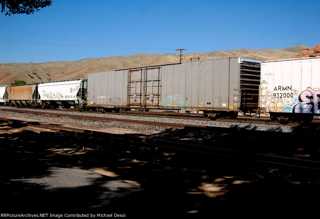 IC grey Hy Cube boxcar ( #680125) in the consist of a westbound UP ...