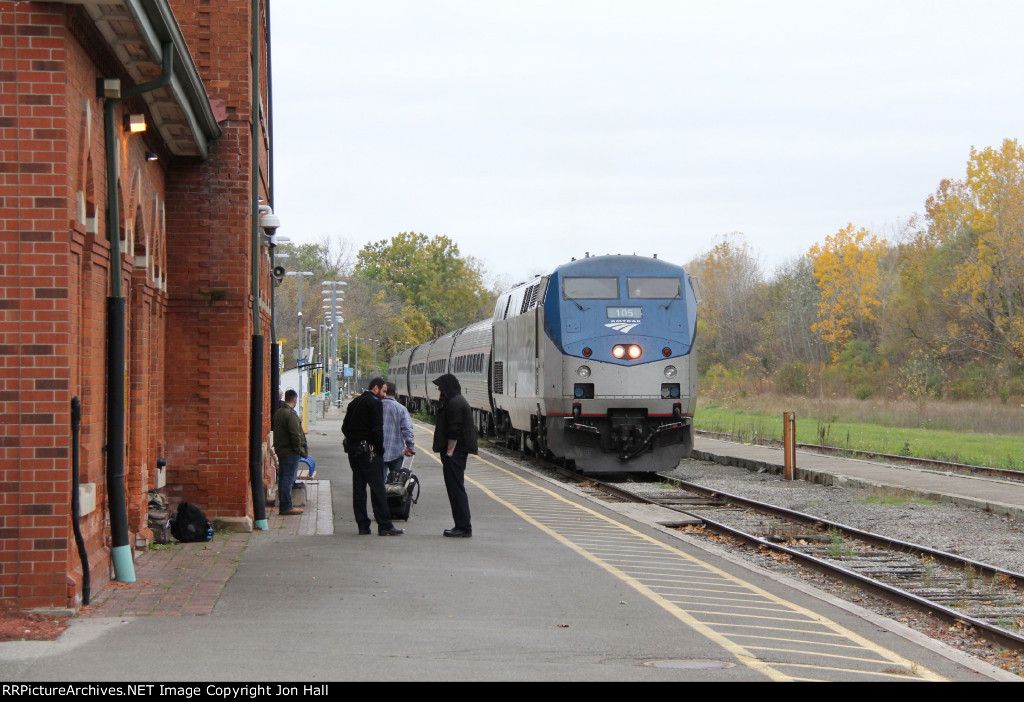 An Amtrak crew waits on the platform for VIA 97 to come to a stop
