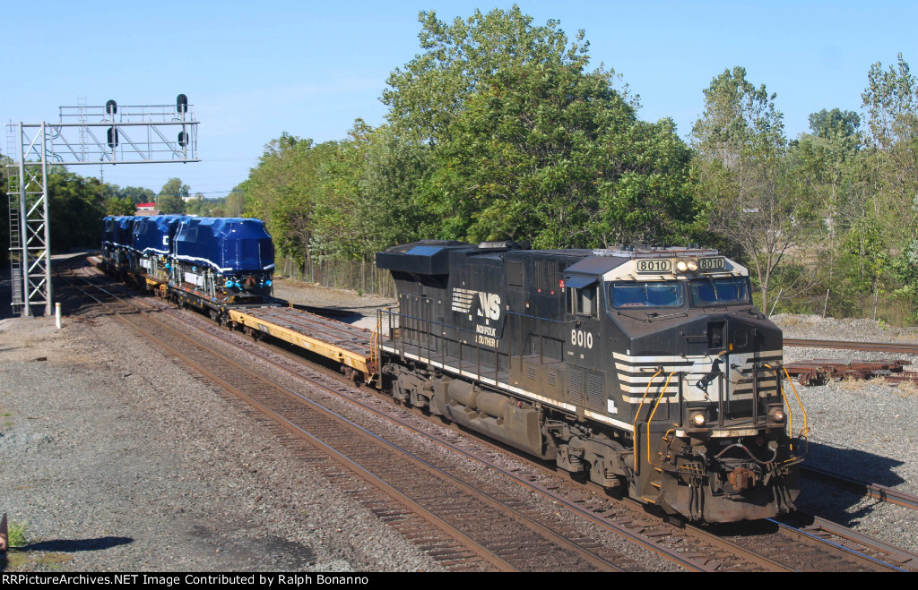 NS 8010 on train 056 eith three export locomotives under wraps crossing ...