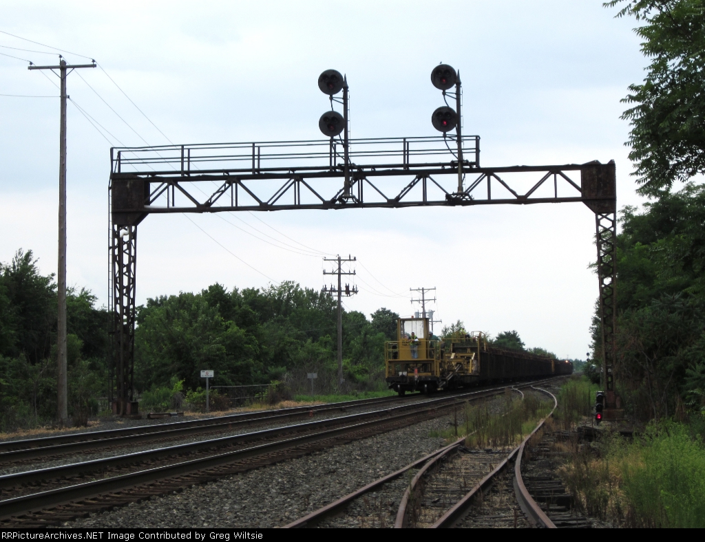 A CSX rail train passes under the signal tower