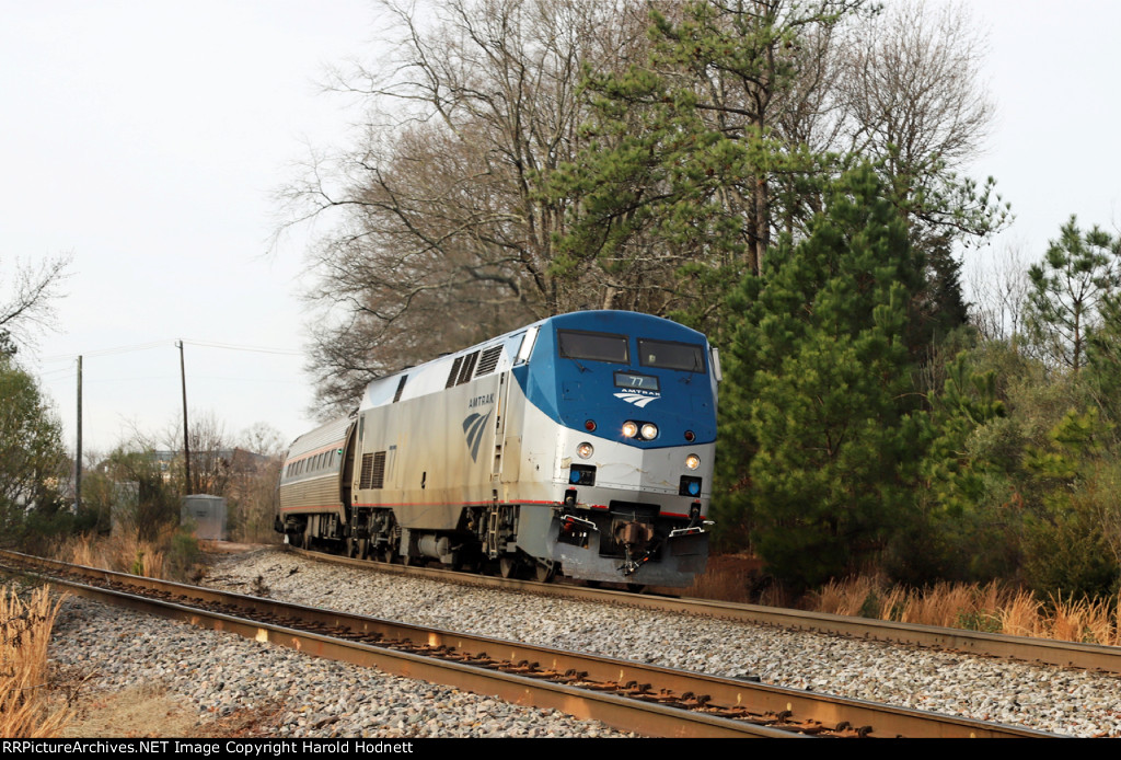 AMTK 77 leads train P080-12 away from the station
