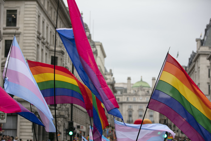 People wave LGBTQ gay pride rainbow flags at a pride event - Beaver ...