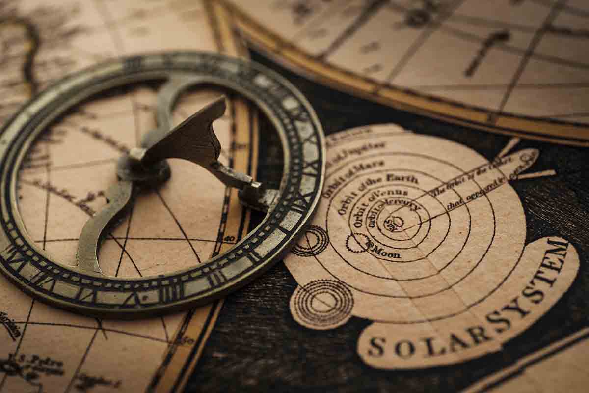 Close-up of sundial and solar system chart on table - StockFreedom ...