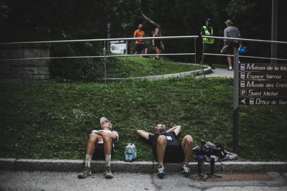 2024 UTMB photo gallery finisher and media crew laying by finish – iRunFar